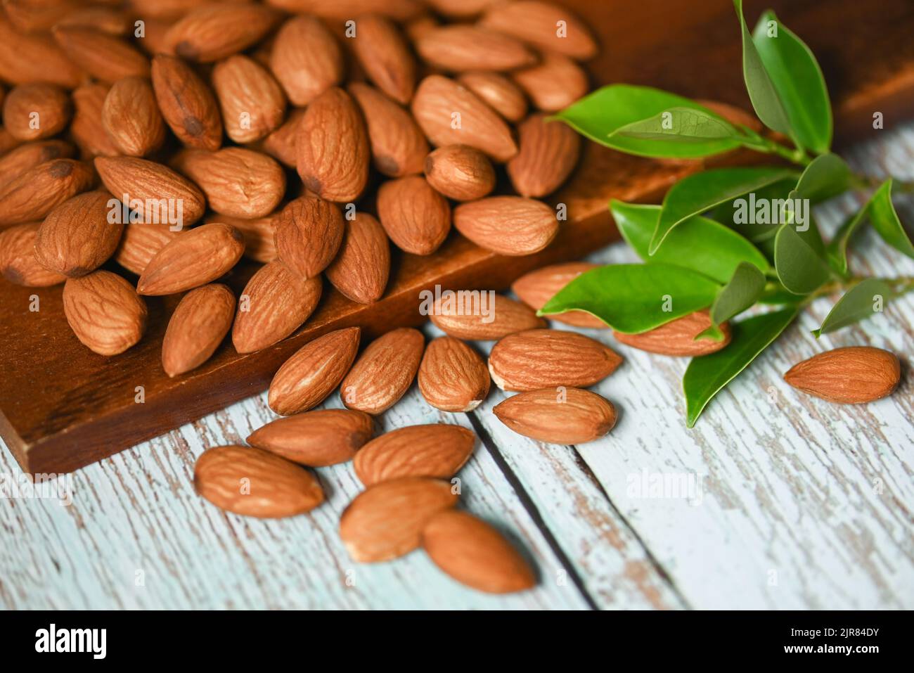 Almonds nuts on wooden background white green leaf , Delicious sweet ...