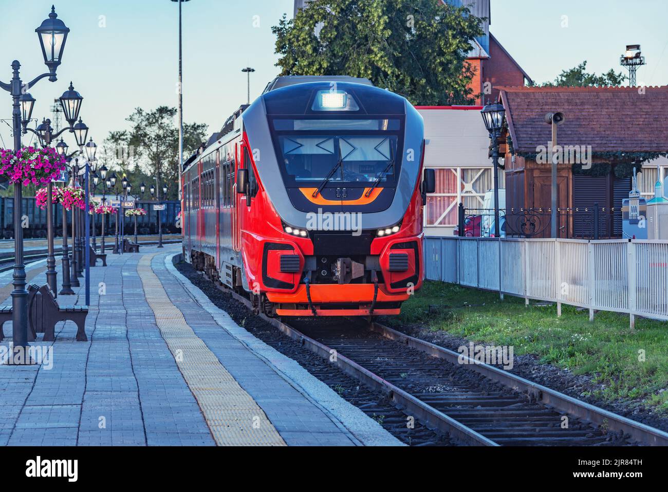Passenger train stands by the wooden platform before departure Stock ...