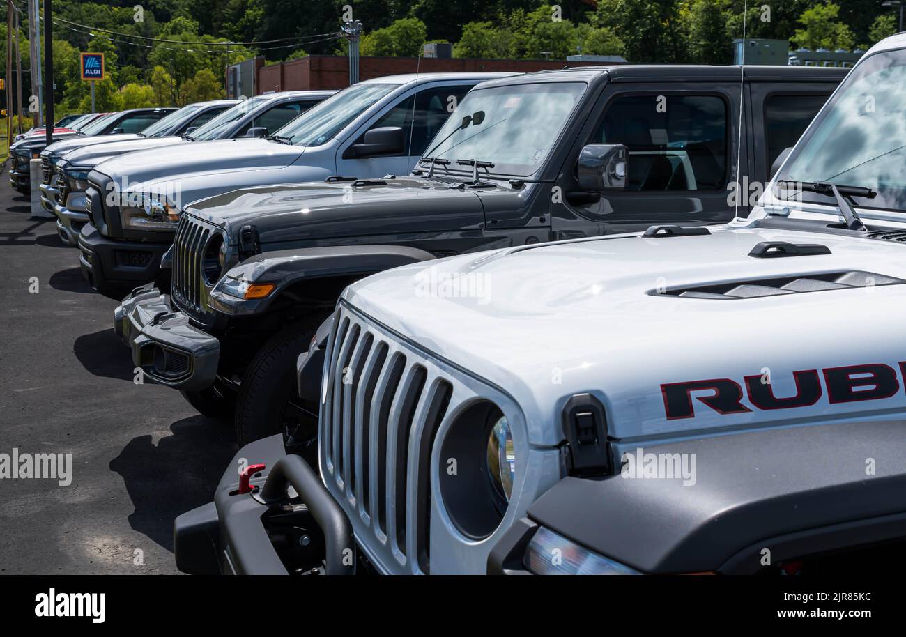 Several Jeep Wranglers and Dodge Ram trucks lined up at a dealership on ...