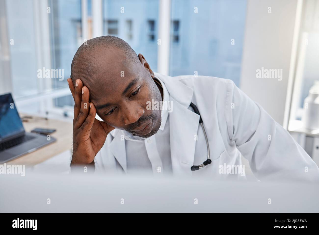 Stress, anxiety and sad doctor at work on computer, sick and headache ...