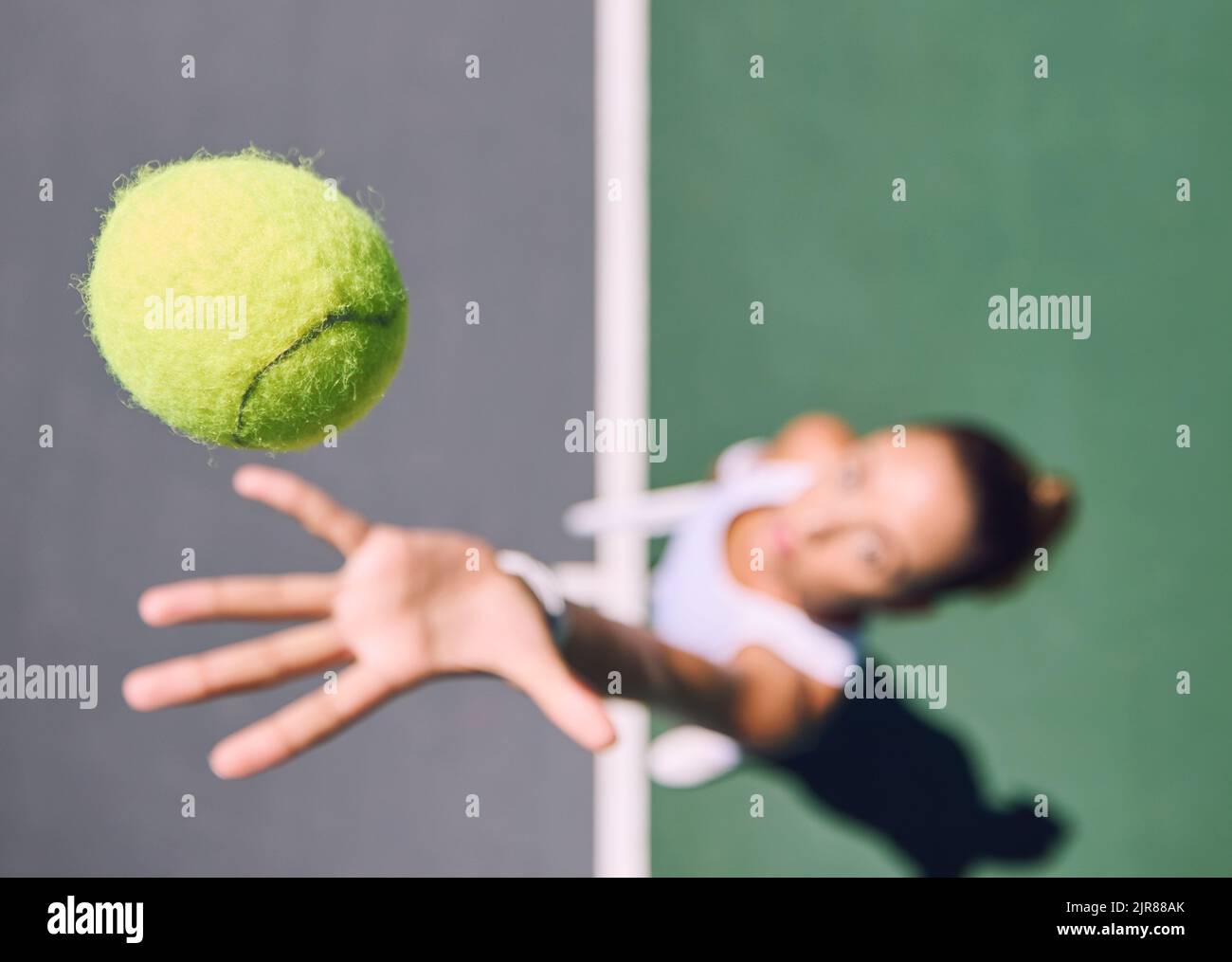 Tennis ball, sports and female player throwing and serving on a court ...