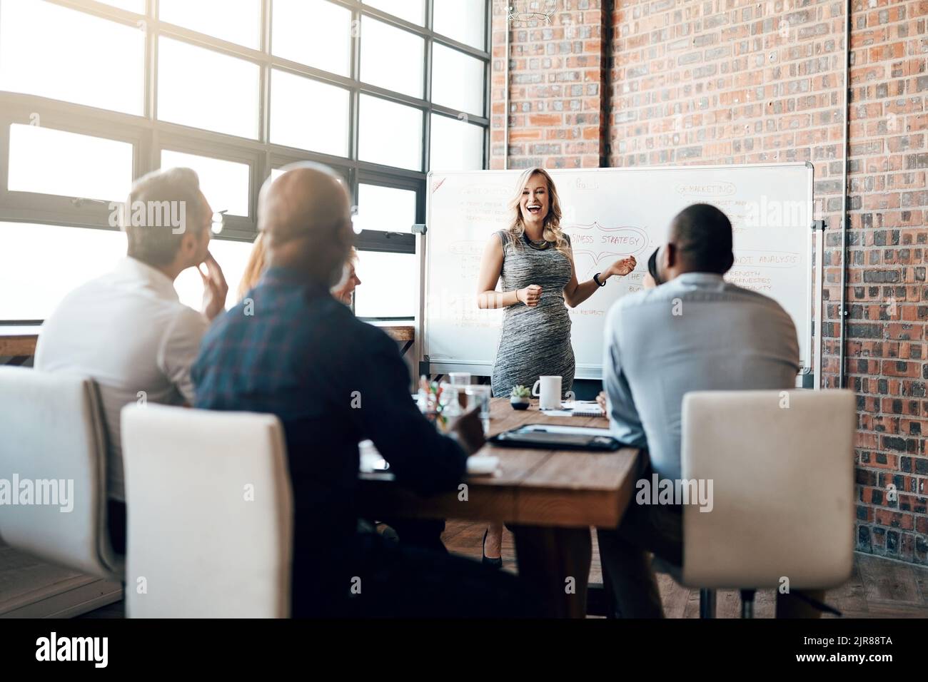 Doing a handover with her team before her maternity leave. a pregnant ...
