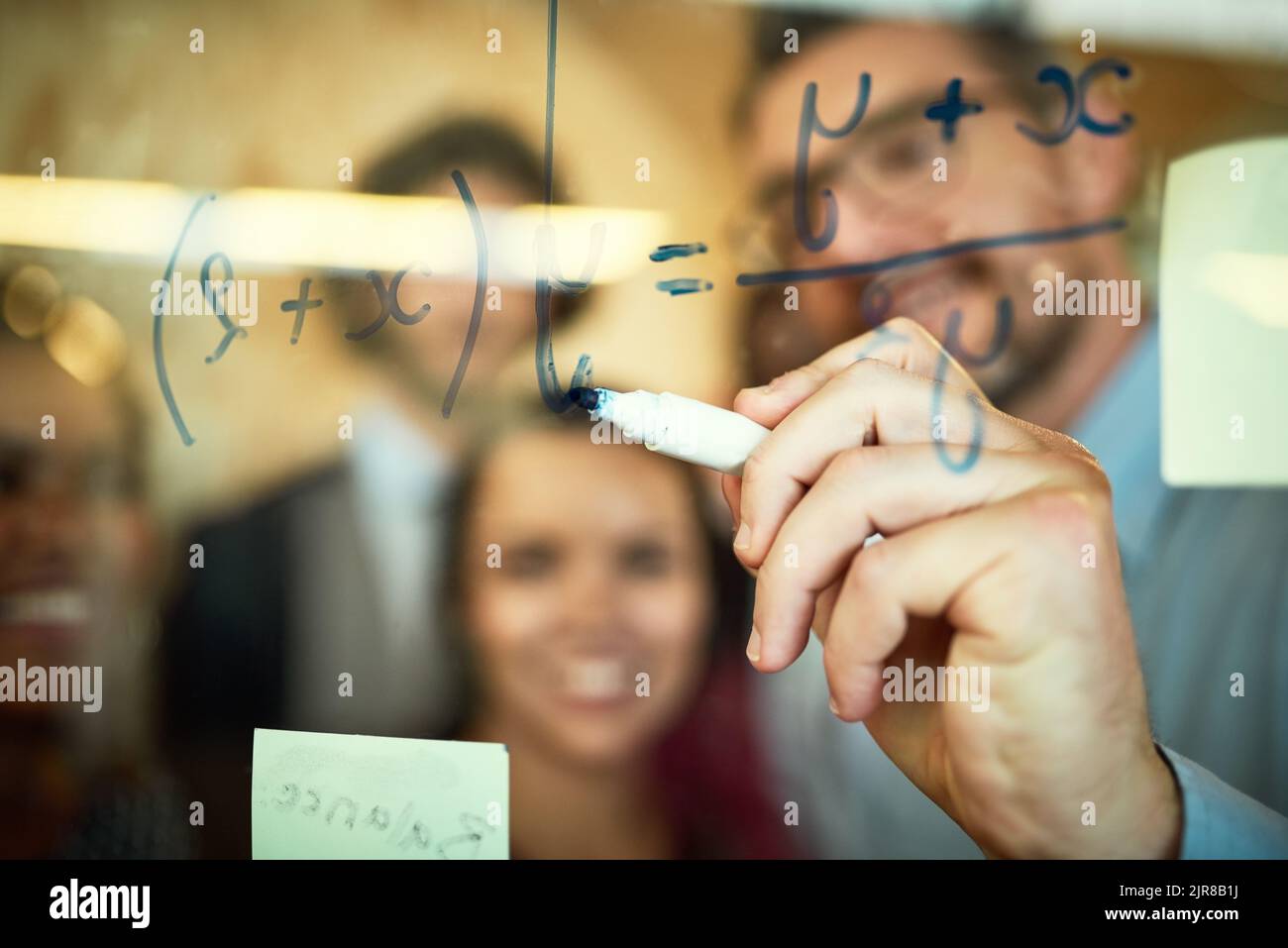 Every idea has a beginning. coworkers using sticky notes on a glass ...