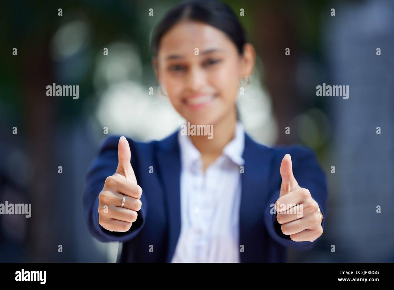 Thumbs up, blurred and working woman does agree by doing hand gesture ...
