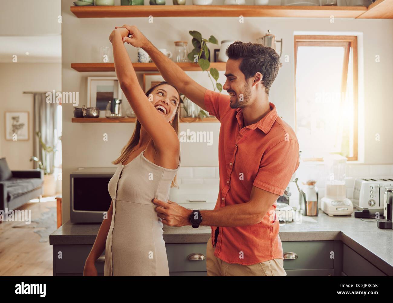 Joyful, dancing and loving couple bonding and having fun in the kitchen ...