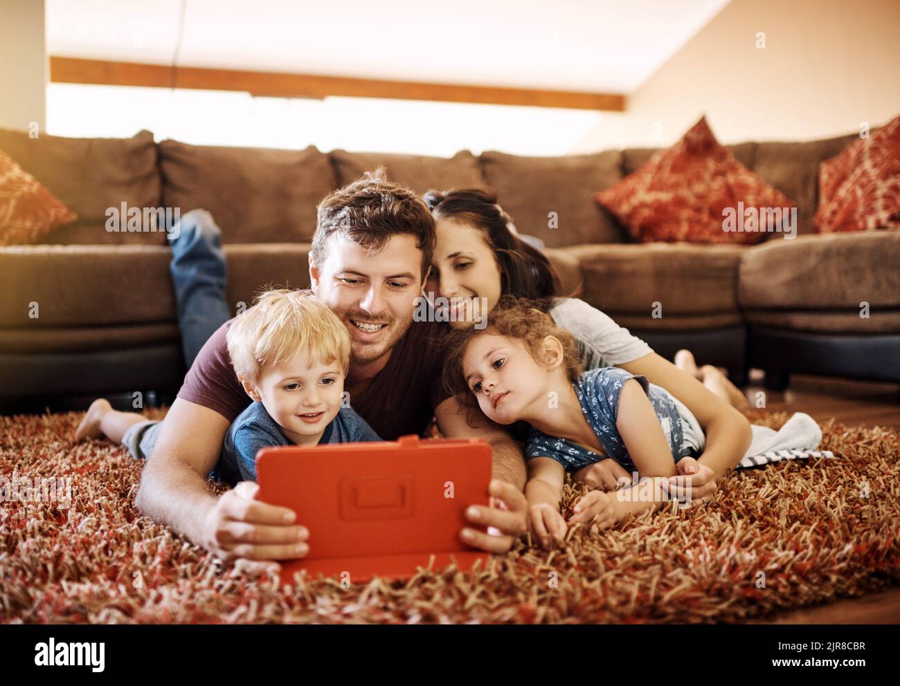 Technology keeps everyone entertained. a happy young family looking at ...