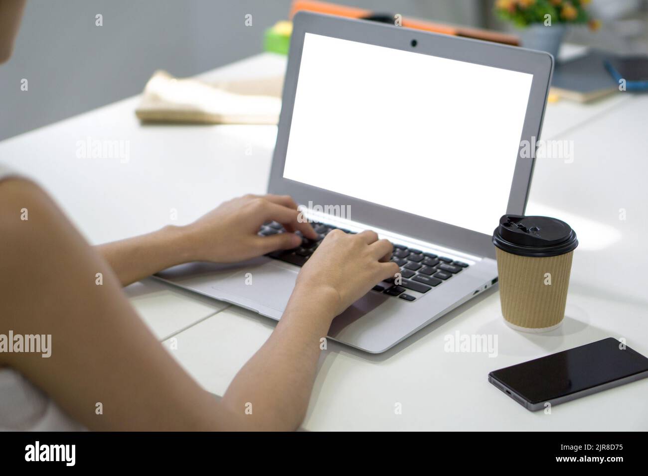 Back view of businesswoman sit at desk in office typing on laptop ...