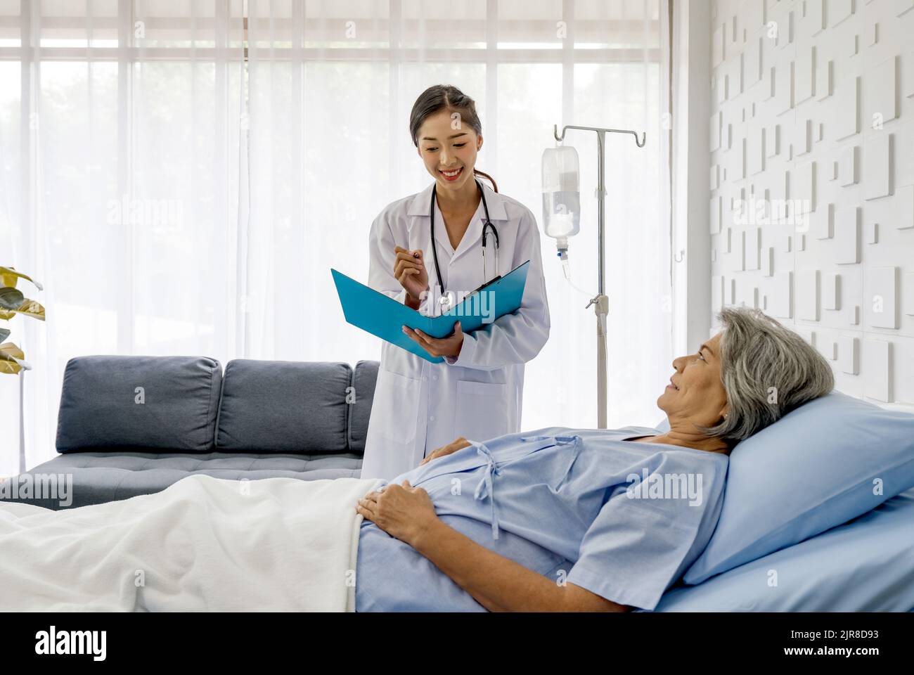 Young asian doctor in white gown with stethoscope and document folder ...