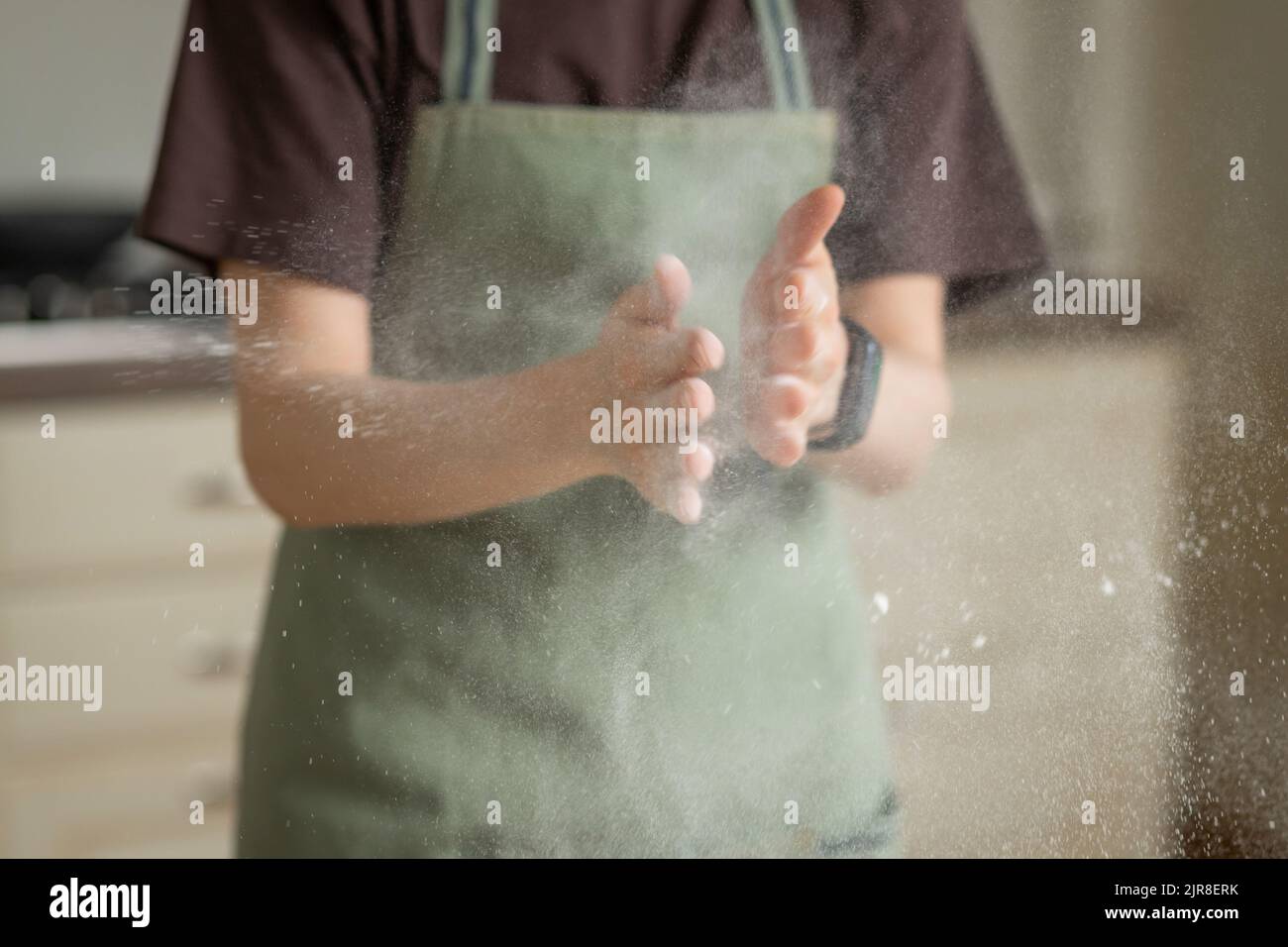 Flour scatters in different directions from the clap in the hands of ...