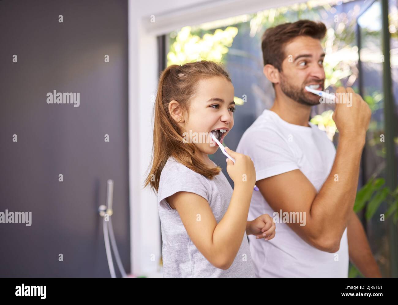 This is how we brush our teeth. a handsome Dad and his daughter ...