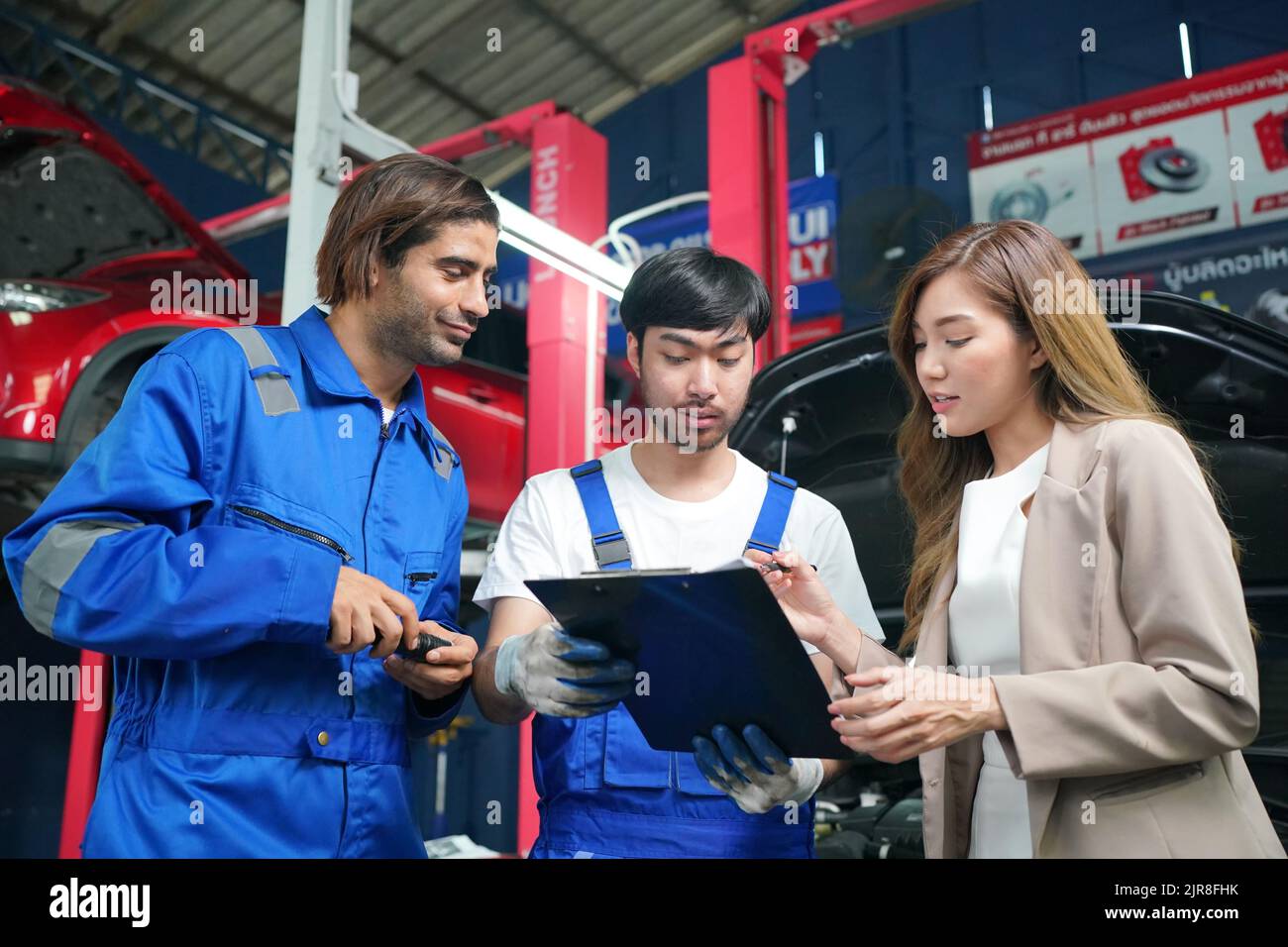 Male car operator wearing blue overalls,cap and gloves working under ...