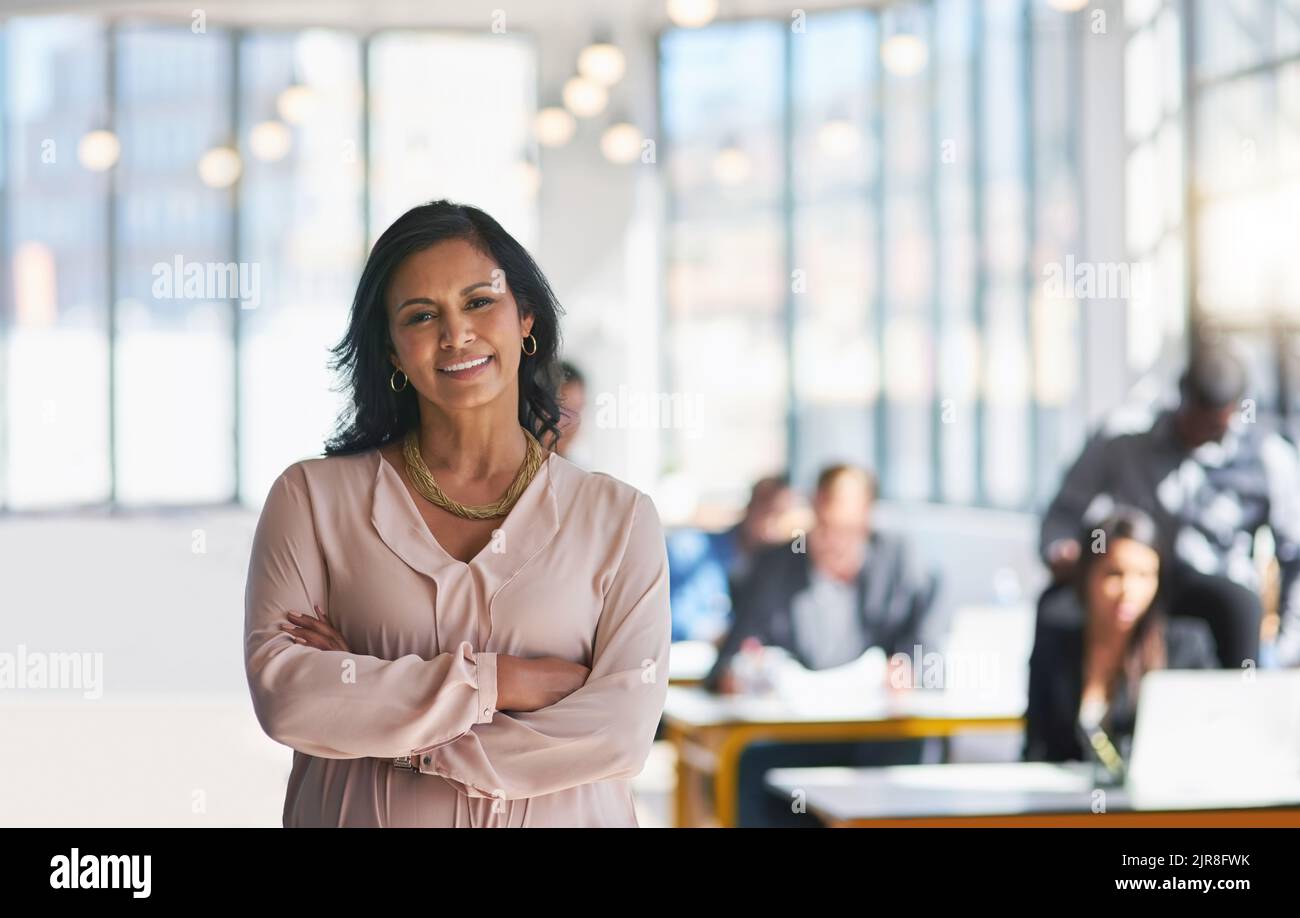 Im full of bright ideas. Portrait of an ambitious young designer posing with her team in the ...