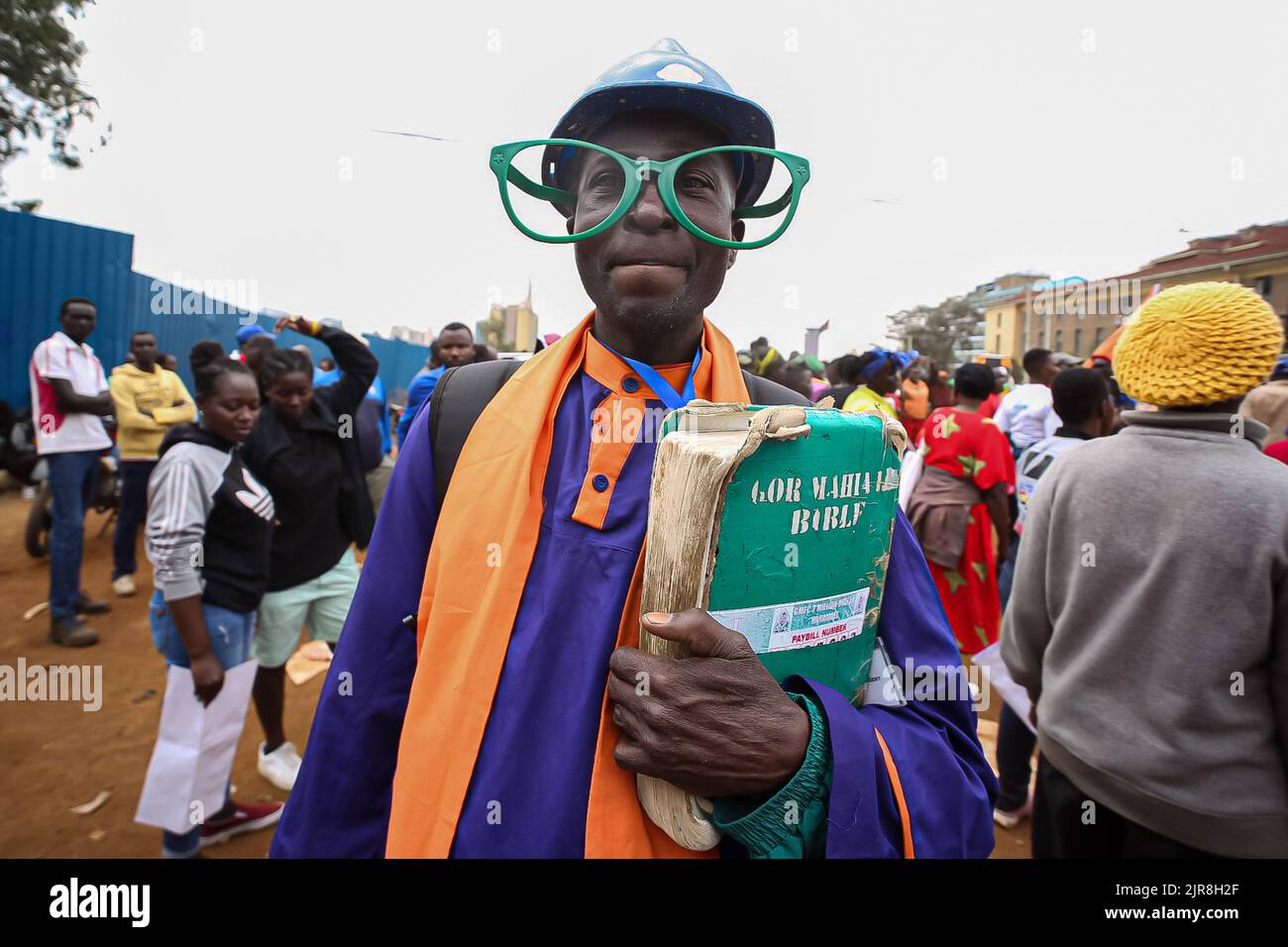 A supporter of the Azimio la Umoja One Kenya coalition carries a bible ...
