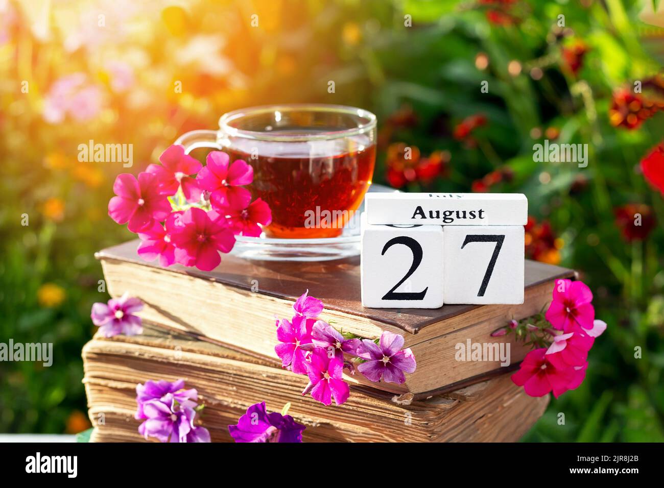 August 27. Cup of tea and calendar date on stack of books against ...