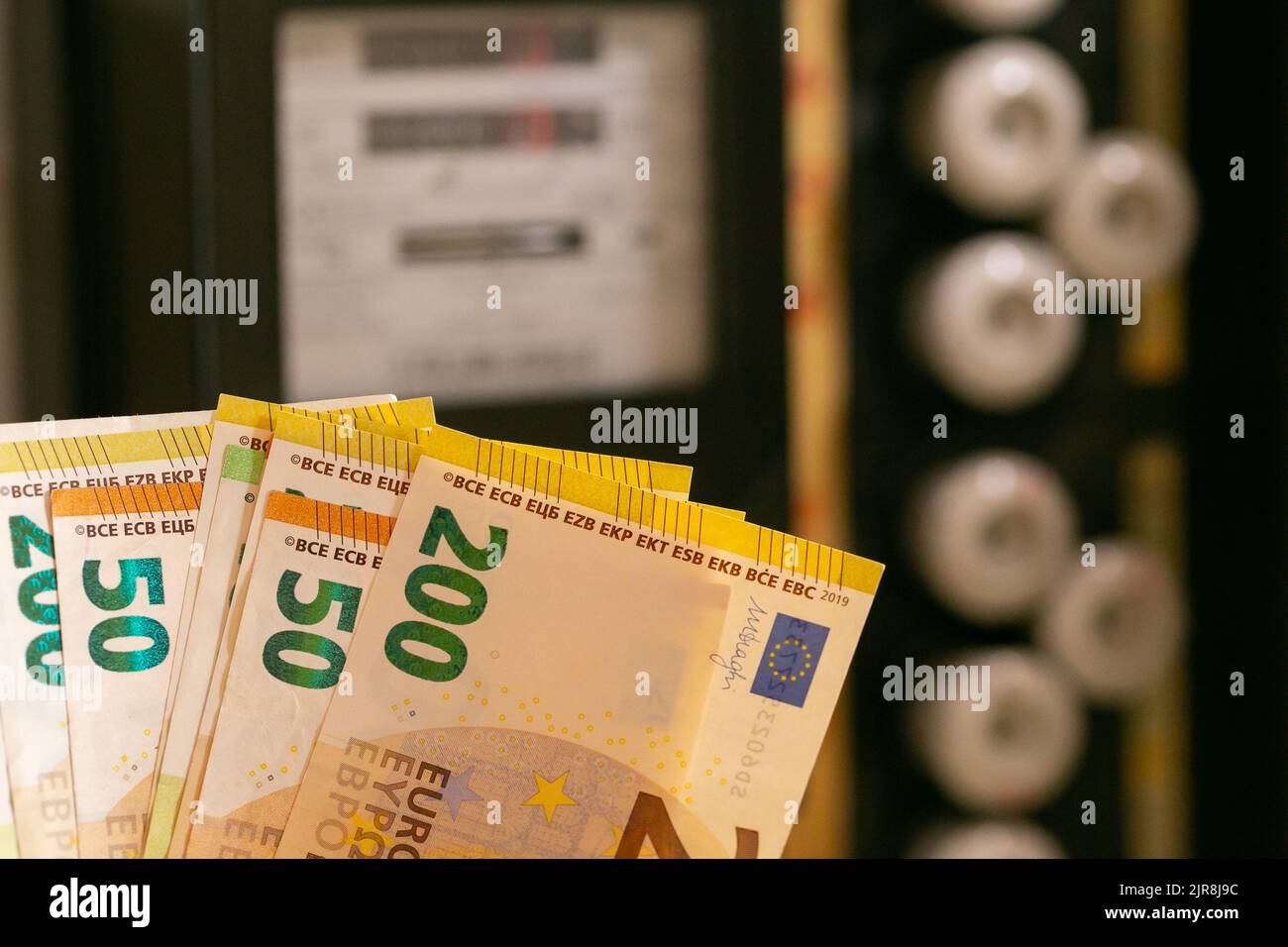 Electricity cost.Hand holding bills on electric meter background ... Electricity cost.Hand holding bills on electric meter background ...