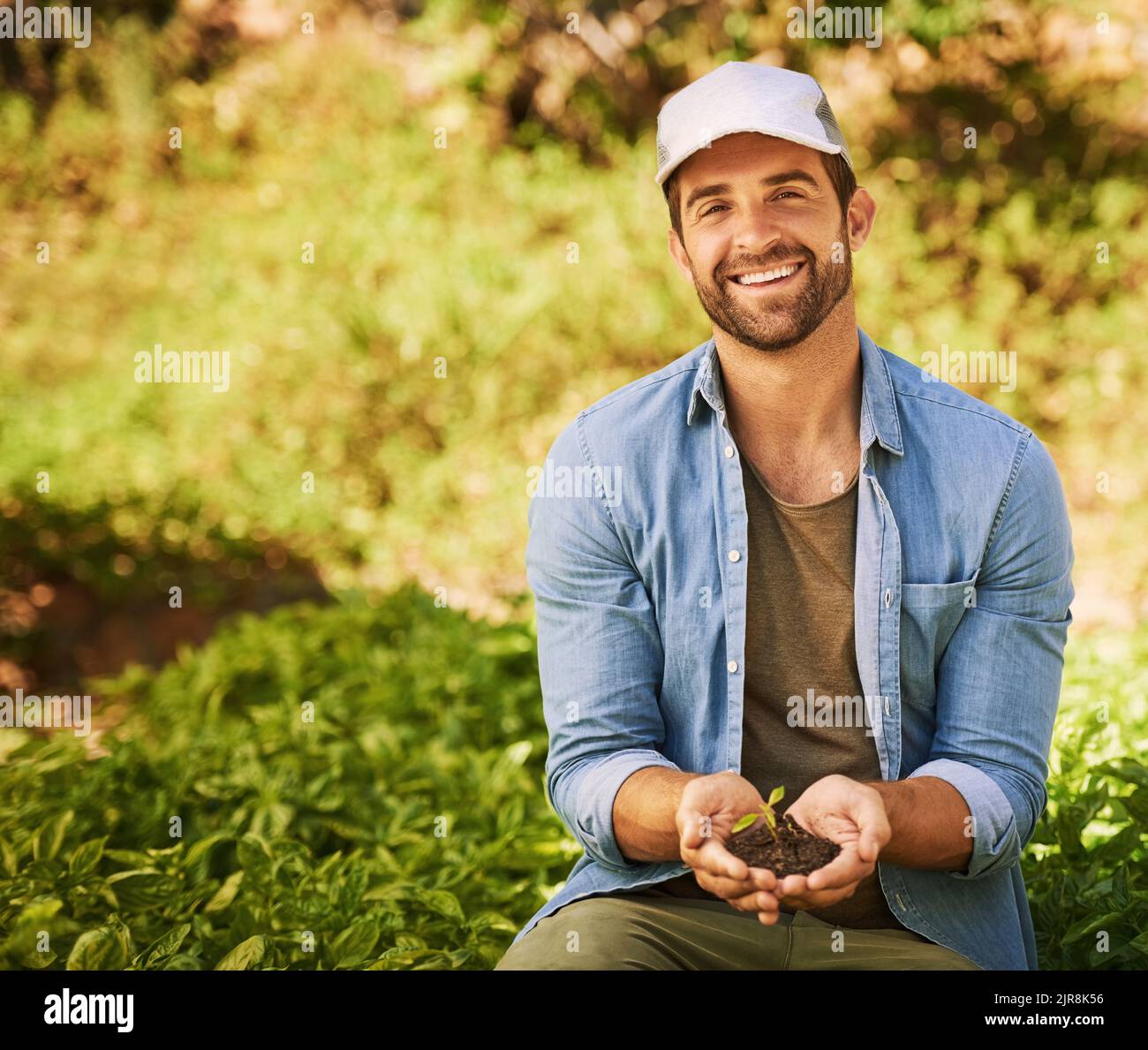 It all started with a seedling. Portrait of a happy young farmer ...