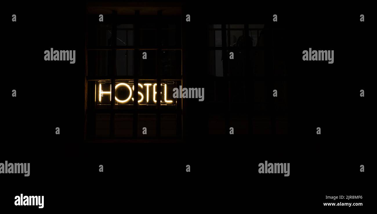 Hostel inscription in neon lights at night. Electric sign at night ...
