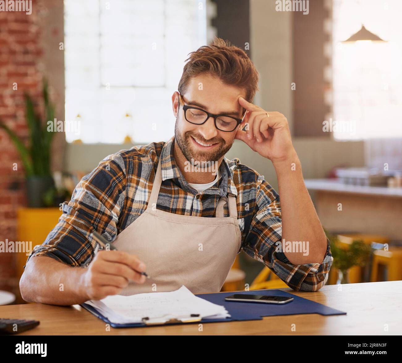 Hes got a head for numbers. a happy young business owner doing admin at ...