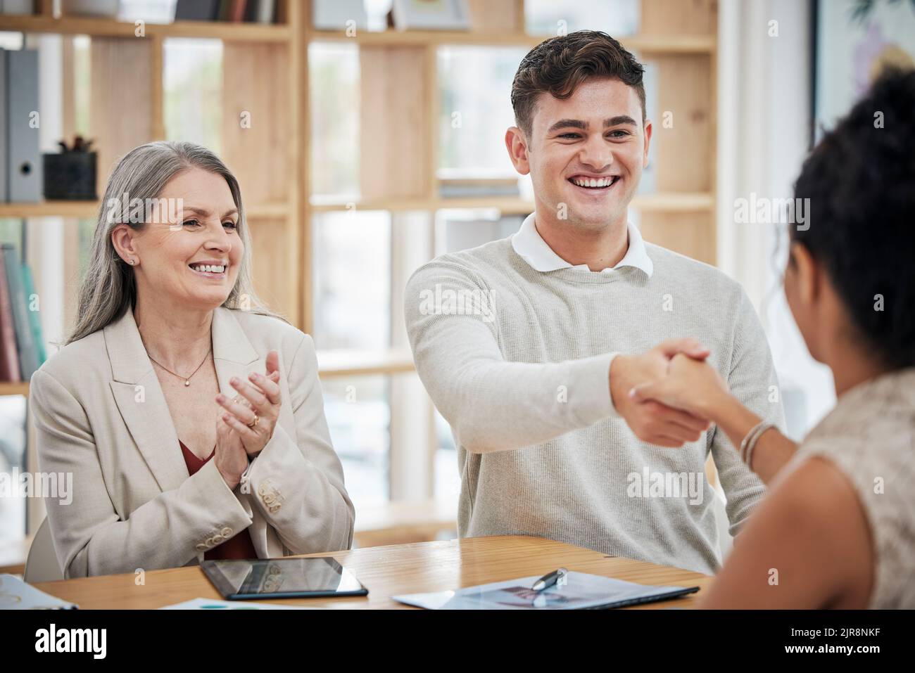 Happy business people shaking hands, meeting and greeting in an office ...