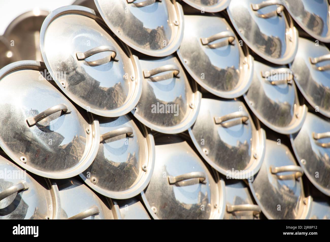 a lot of pot lids as a backdrop in the sunlight, a pot lid, kitchen ...