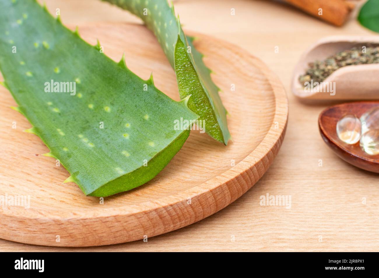 A fresh cut aloe vera on a round wooden plate Stock Photo - Alamy