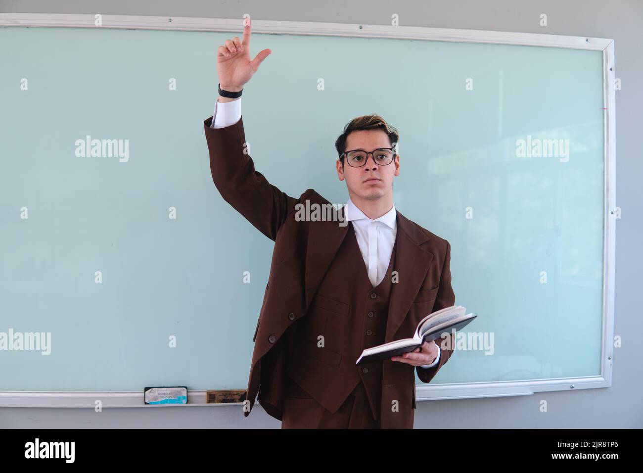 Teacher at the white board with his hand raised. Teacher raising his ...