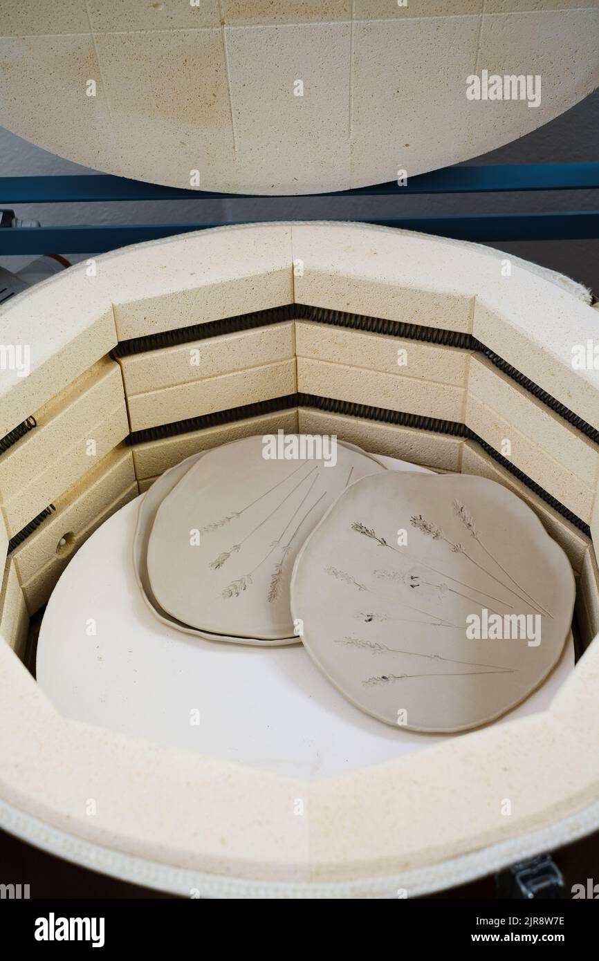 close-up ceramic plates in the kiln, oven for roasting of unbaked clay ...