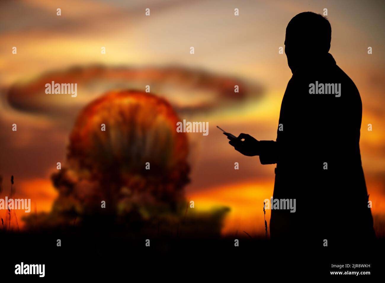 The concept of a nuclear strike. Silhouette of a man with a remote ...
