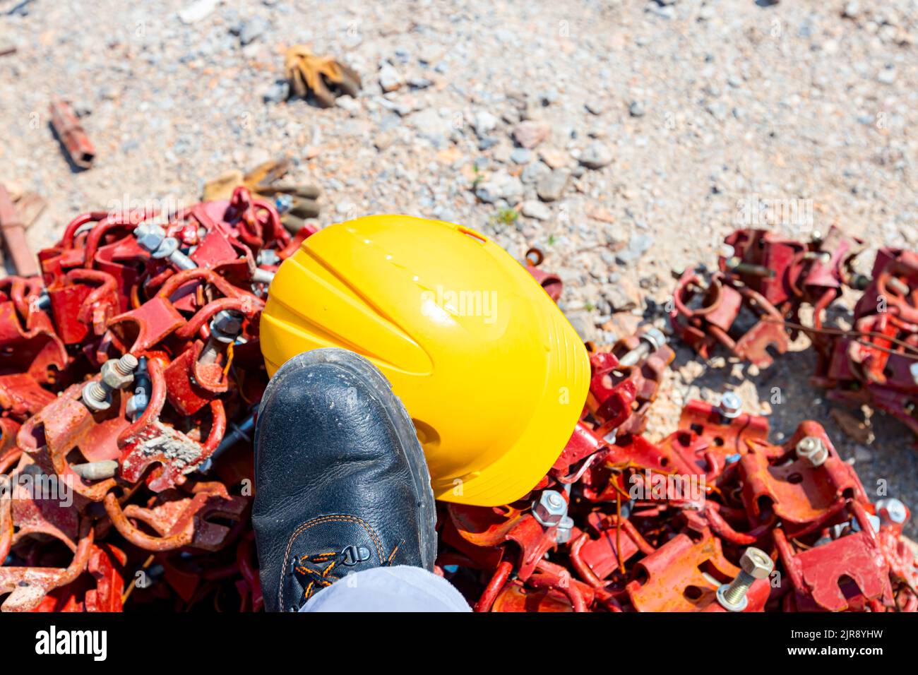 View from above on worker who wears safety shoe and tramples on pile ...