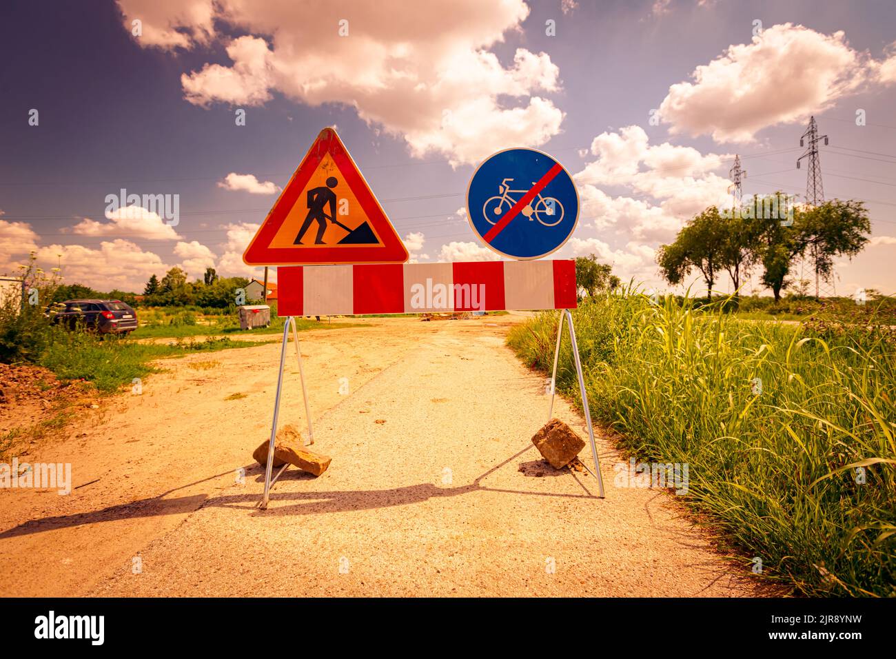 Two signs are set on the road at construction site, triangle sign, work ...