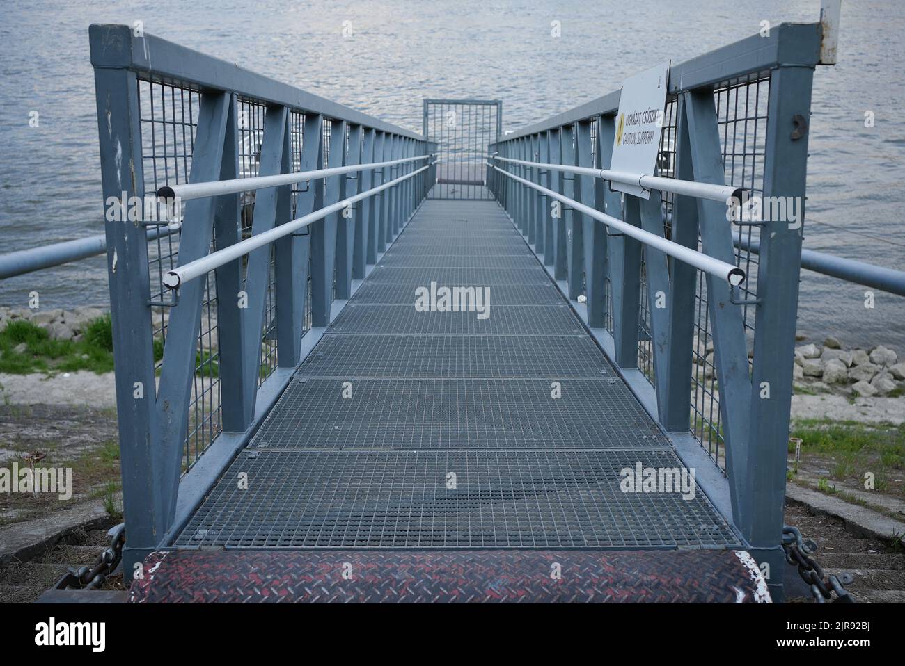 Bridge leading to a gate on the river dock Stock Photo - Alamy