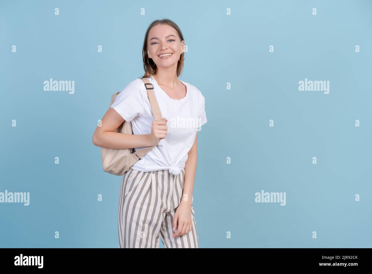 Beautiful girl in white t-shirt with backpack on her back female ...