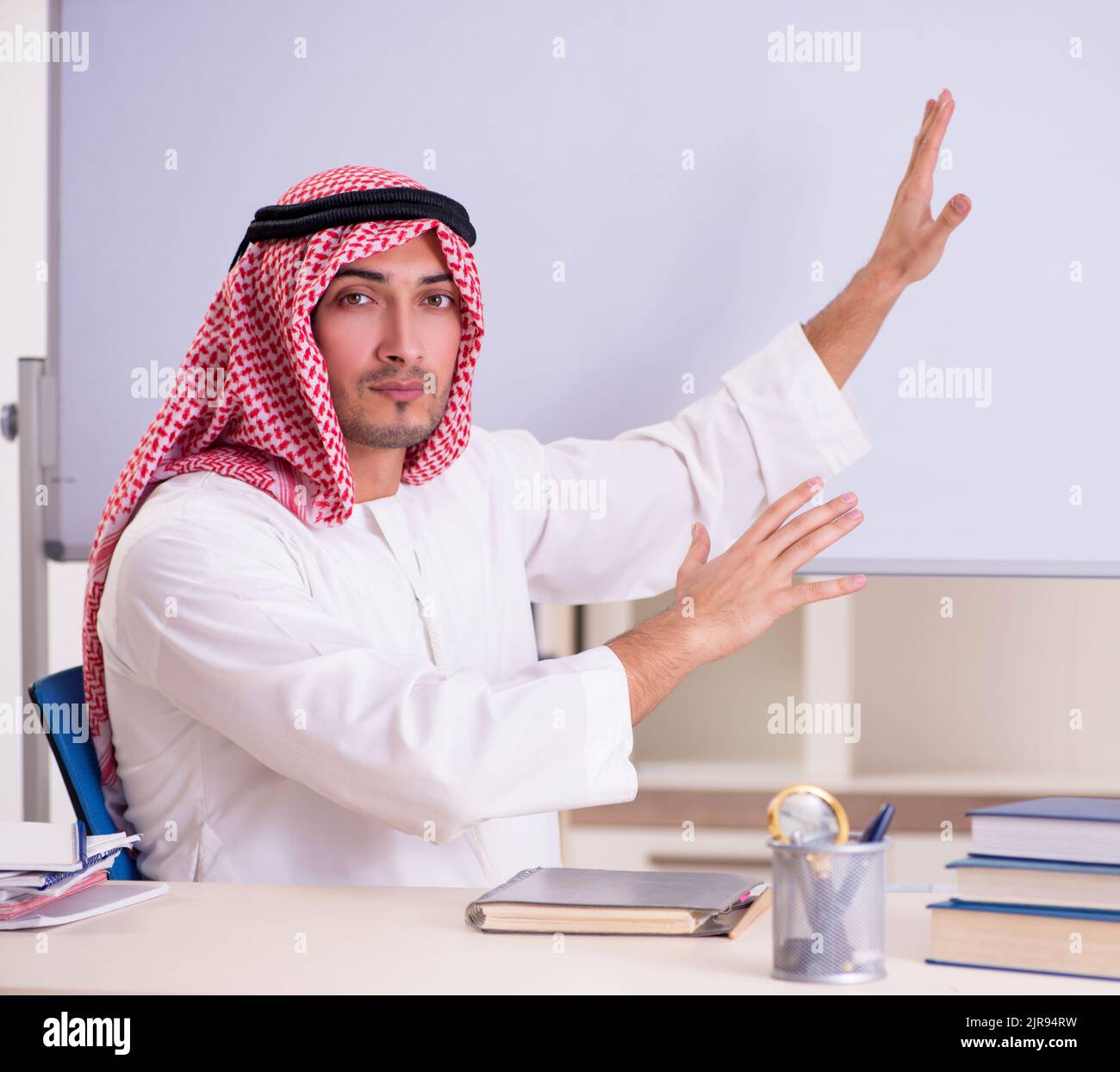 Arab teacher in front of whiteboard Stock Photo - Alamy