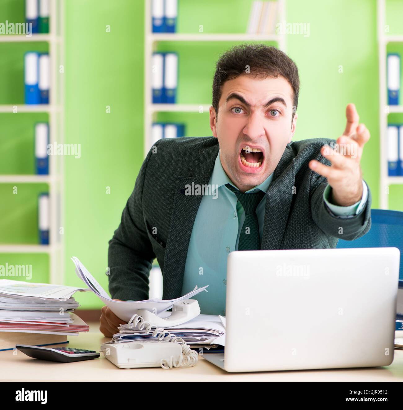 The businessman angry with excessive work sitting in the office Stock ...