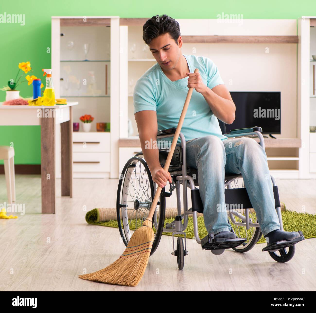 The disabled man on wheelchair cleaning house Stock Photo - Alamy