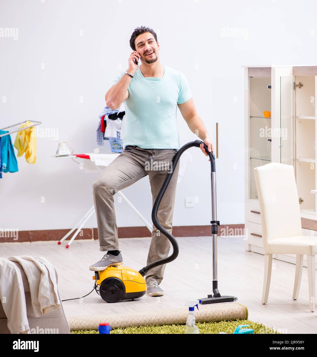 The young man husband doing vacuuming at home Stock Photo - Alamy