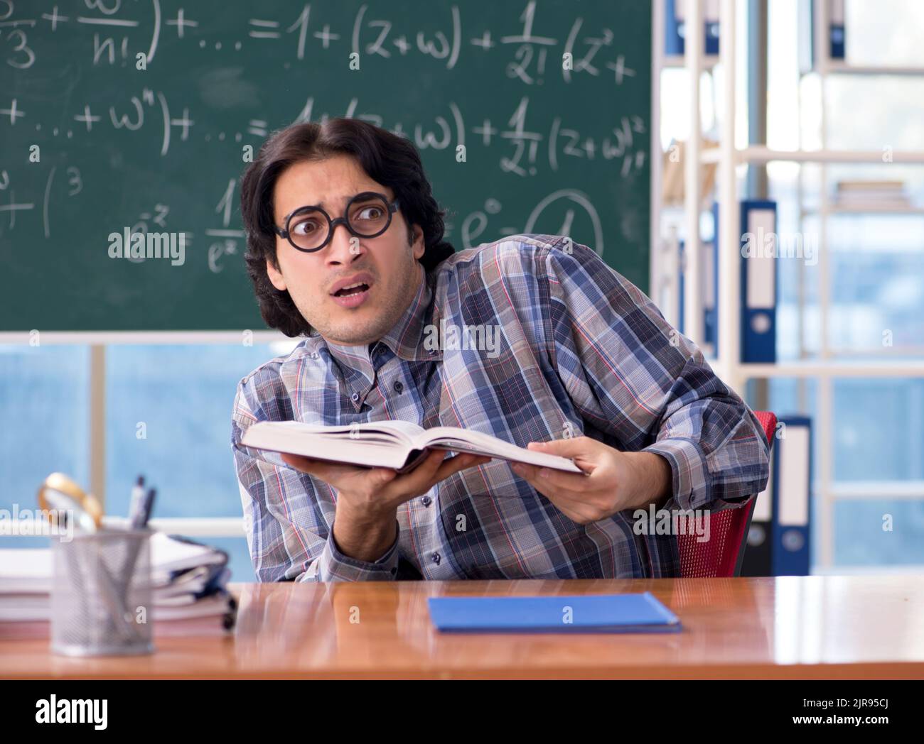 Young funny math teacher in front of chalkboard Stock Photo - Alamy