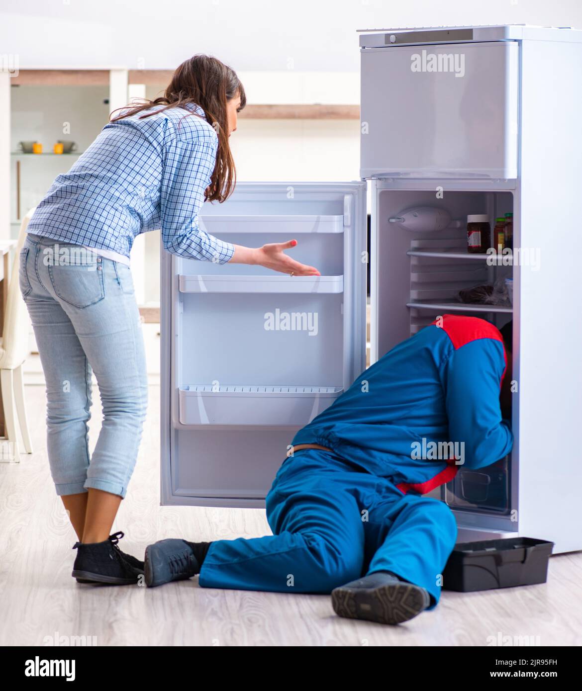 The man repairing fridge with customer Stock Photo - Alamy