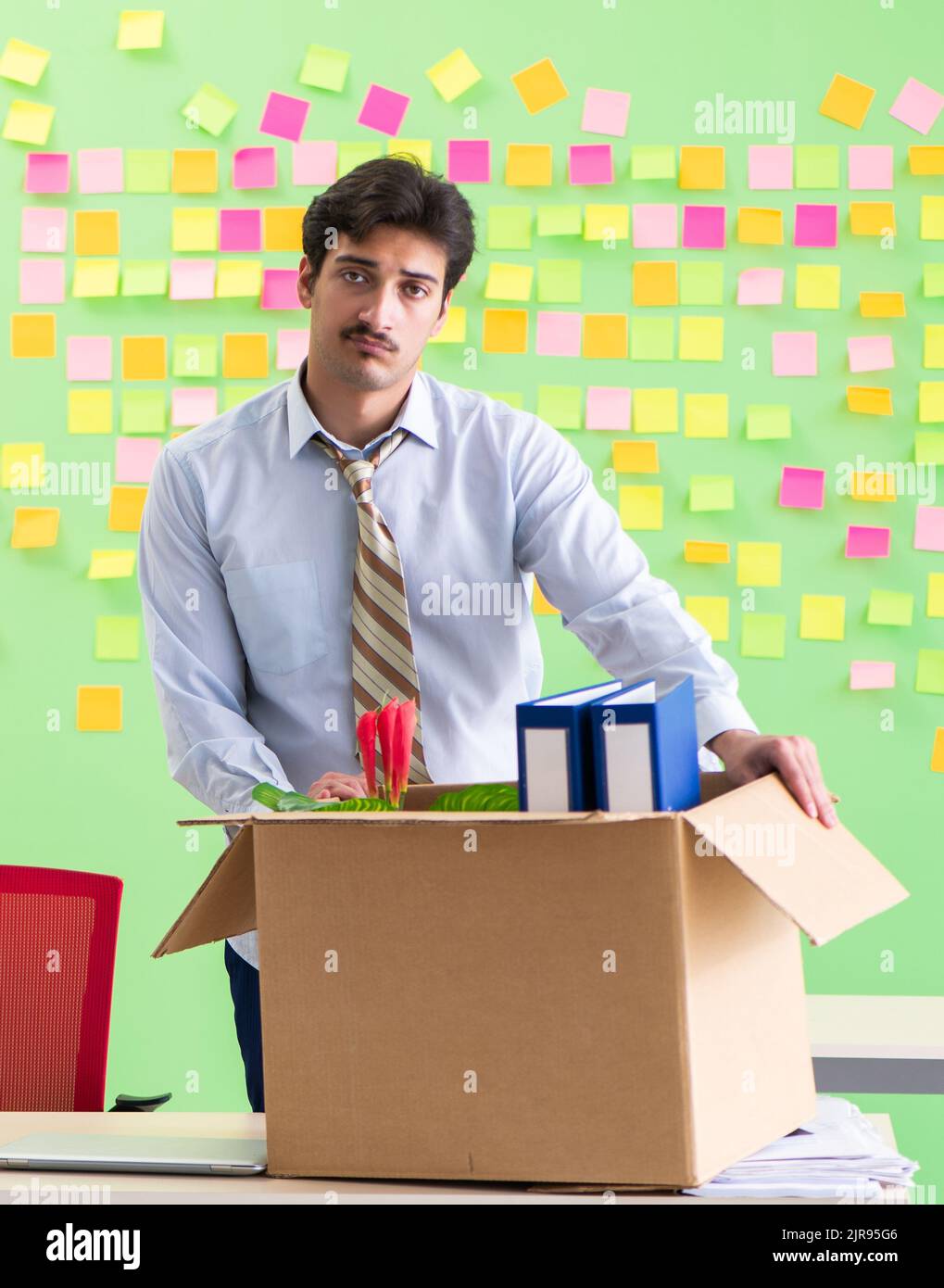 Man collecting his stuff after redundancy in the office with many ...