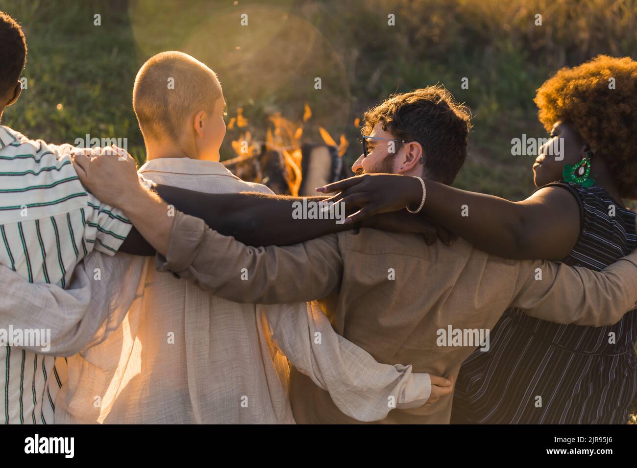 Rear view of multicultural good old friends hugging and having a ...