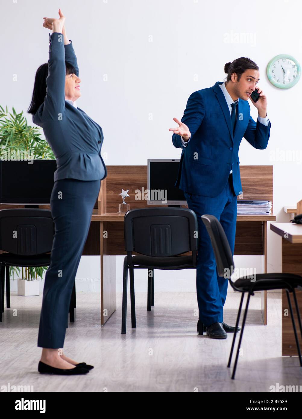 The two employees doing sport exercises in the office Stock Photo - Alamy