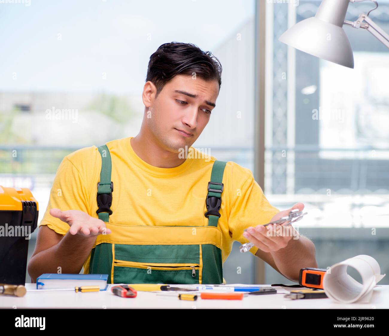 The construction worker sitting at the desk Stock Photo - Alamy
