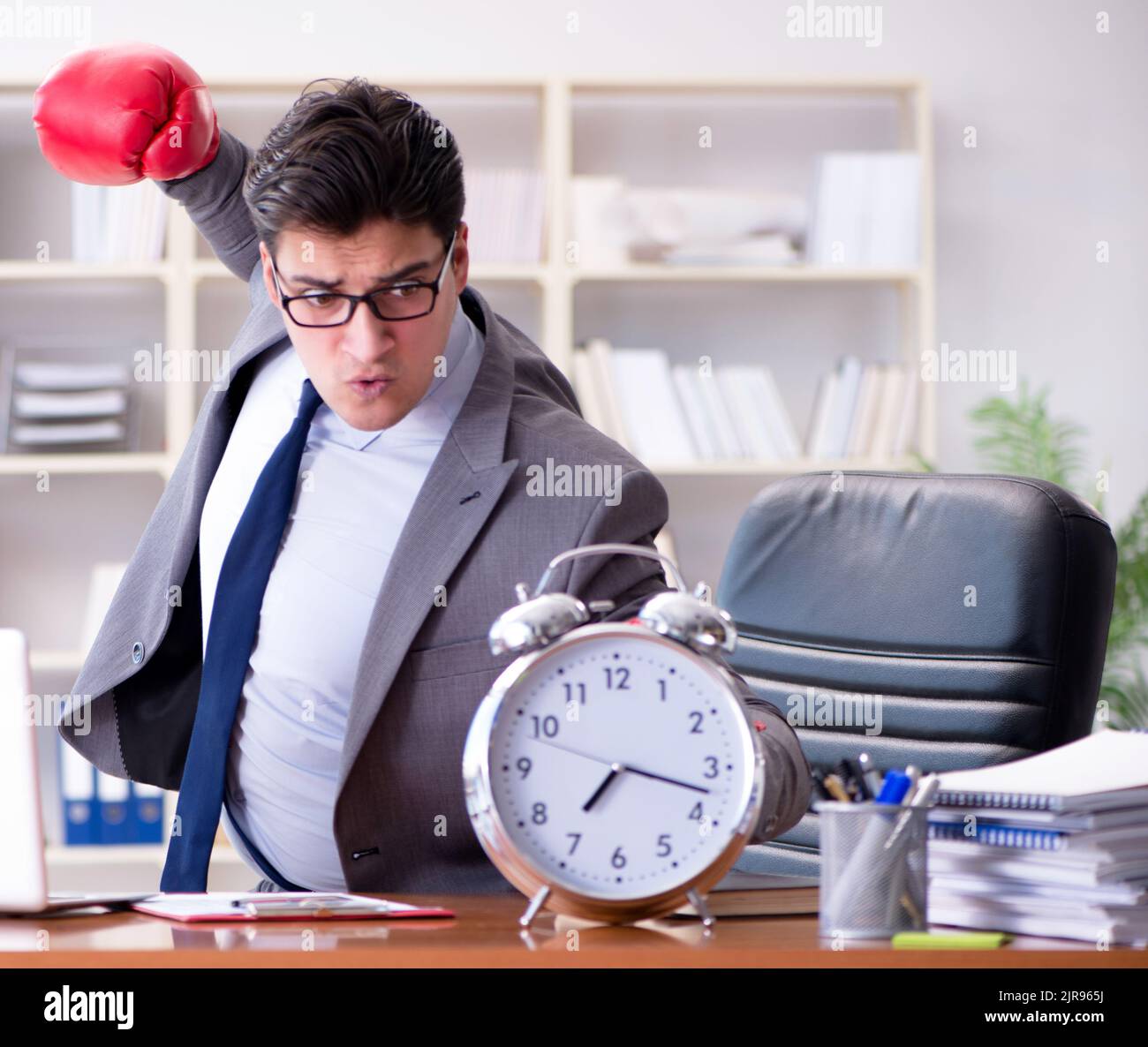 The angry businessman with boxing gloves in time management concept ...