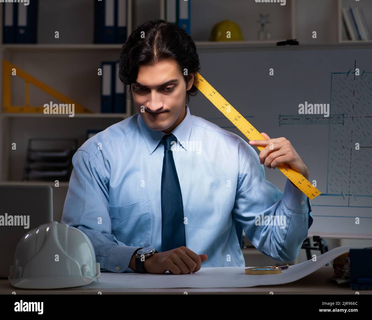 Young male architect working night at office Stock Photo - Alamy