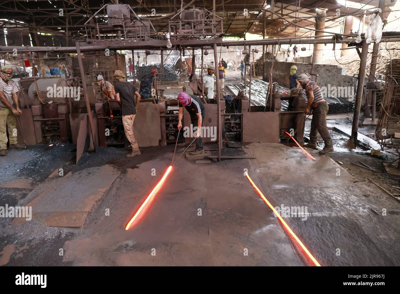 Bangladeshi workers are seen working in the steel re-rolling mill ...