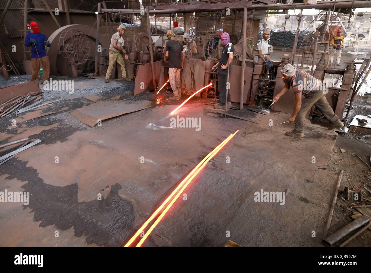 Bangladeshi workers are seen working in the steel re-rolling mill ...