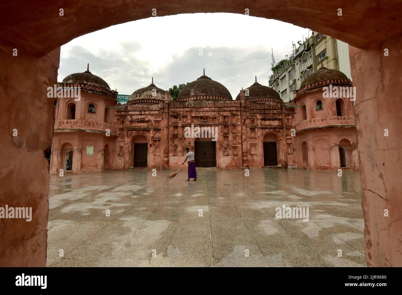 Dhaka. 23rd Aug, 2022. A caretaker cleans the courtyard of the Sat ...