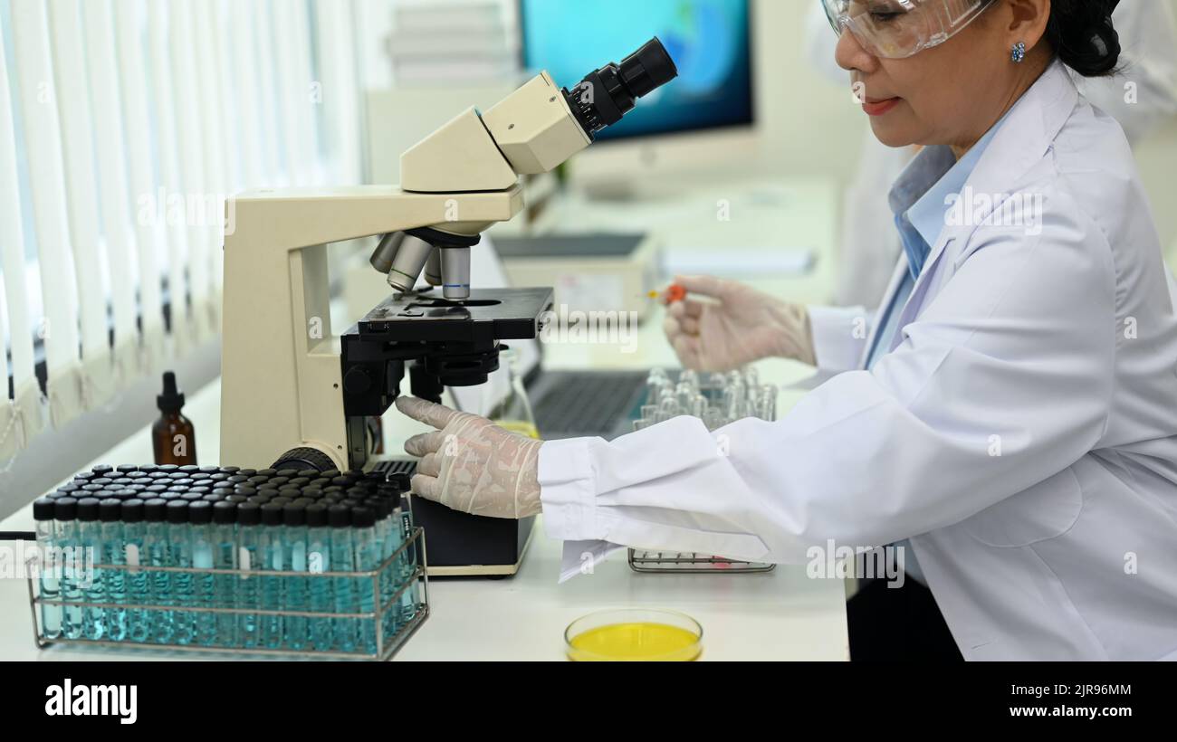 Professional chemistry science in white coat examining samples and ...