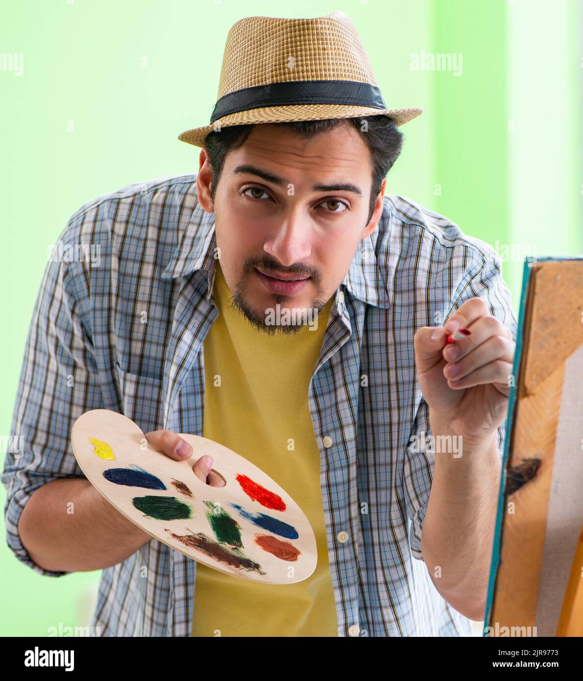 The young male artist working on new painting in his studio Stock Photo ...