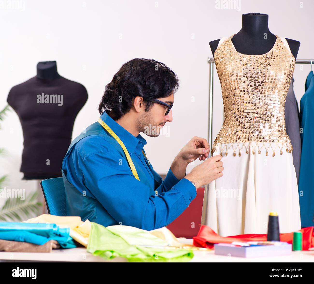 Young male tailor working at workshop Stock Photo - Alamy